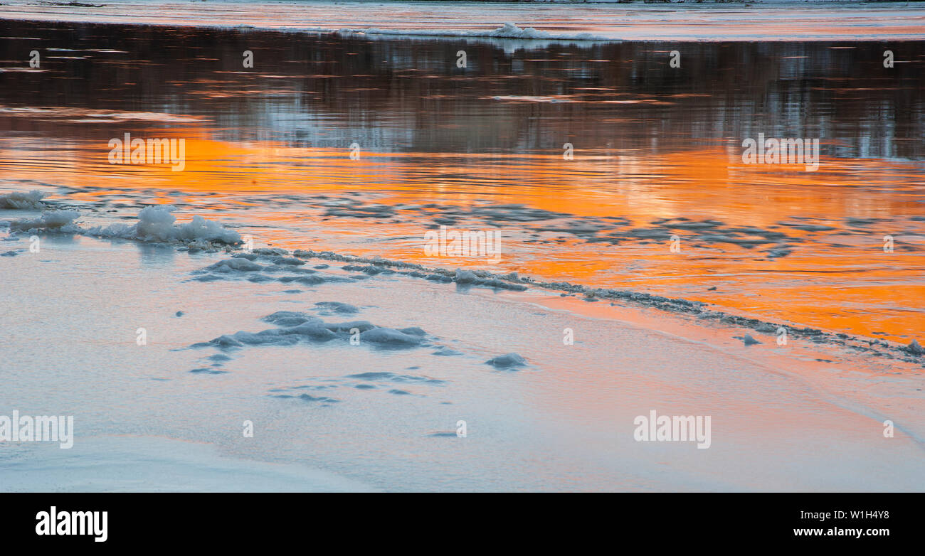 Redrock reflections color the fast running ice flow of the Colorado ...