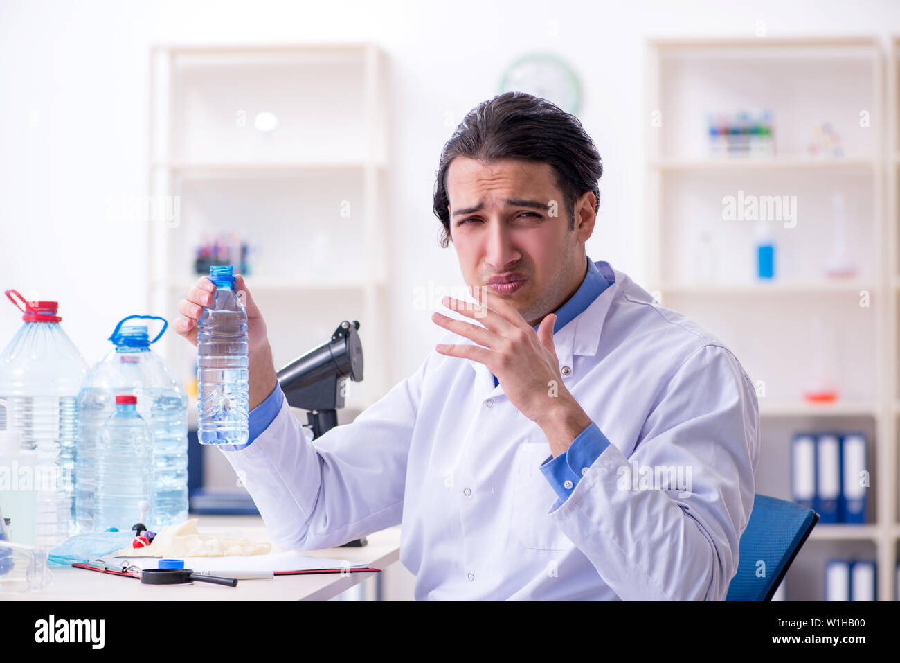 The young male chemist experimenting in lab Stock Photo - Alamy
