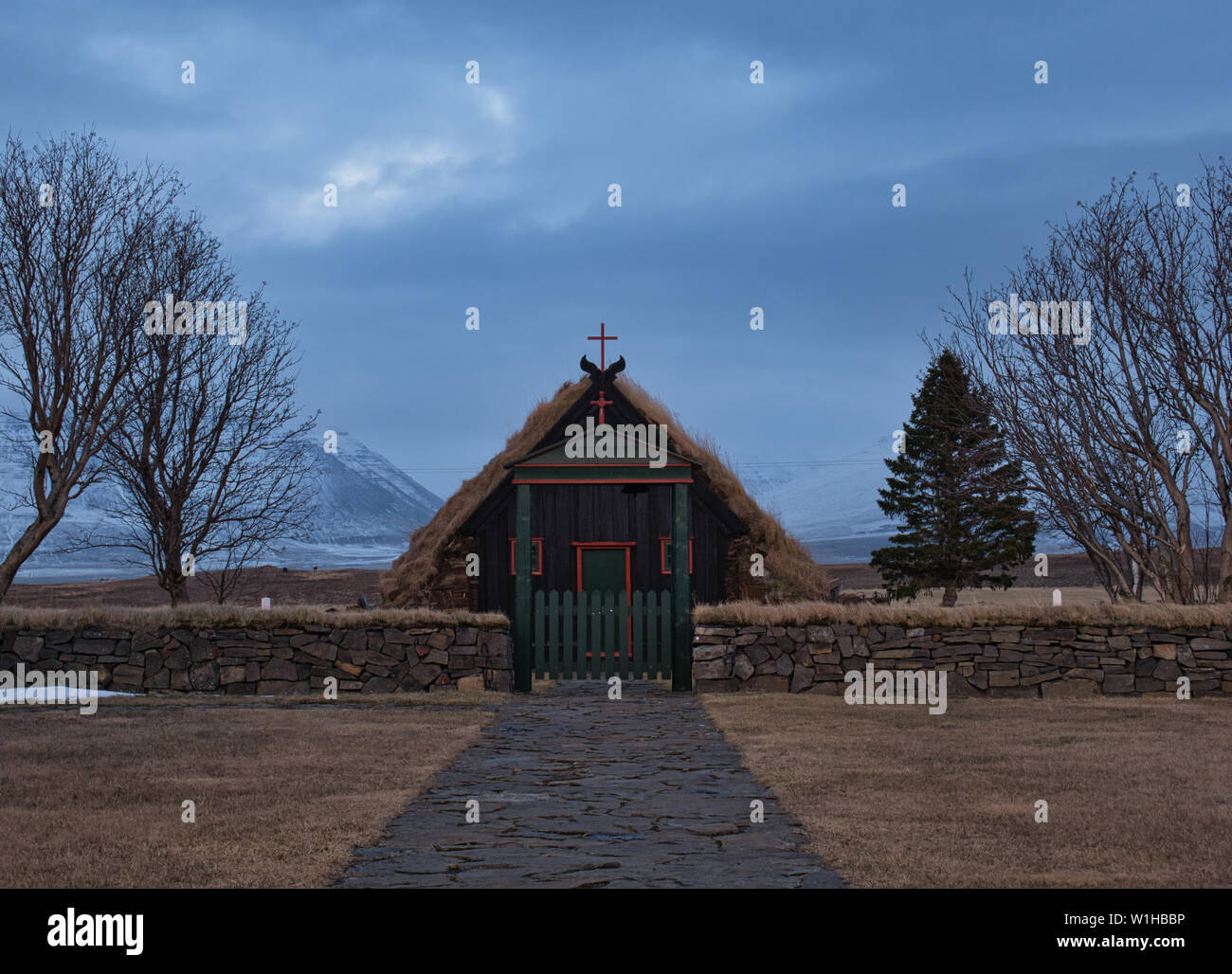 A paved path to a gate in front of a small church Stock Photo - Alamy