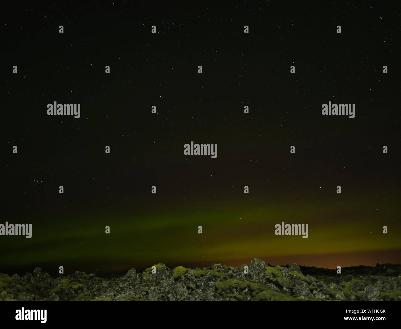Numerous stars and the northern lights on the horizon with volcanic ...