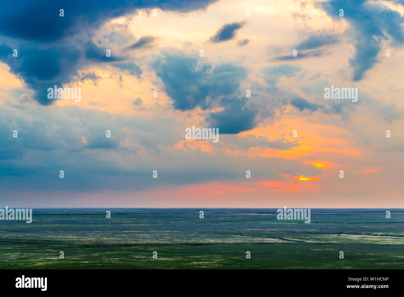 Scenic sunset with clouds in sky in steppe Stock Photo - Alamy