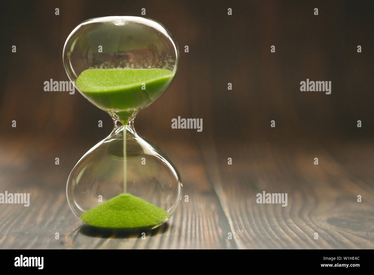 Hourglass with falling sand inside a glass bulb, passing time or lost ...