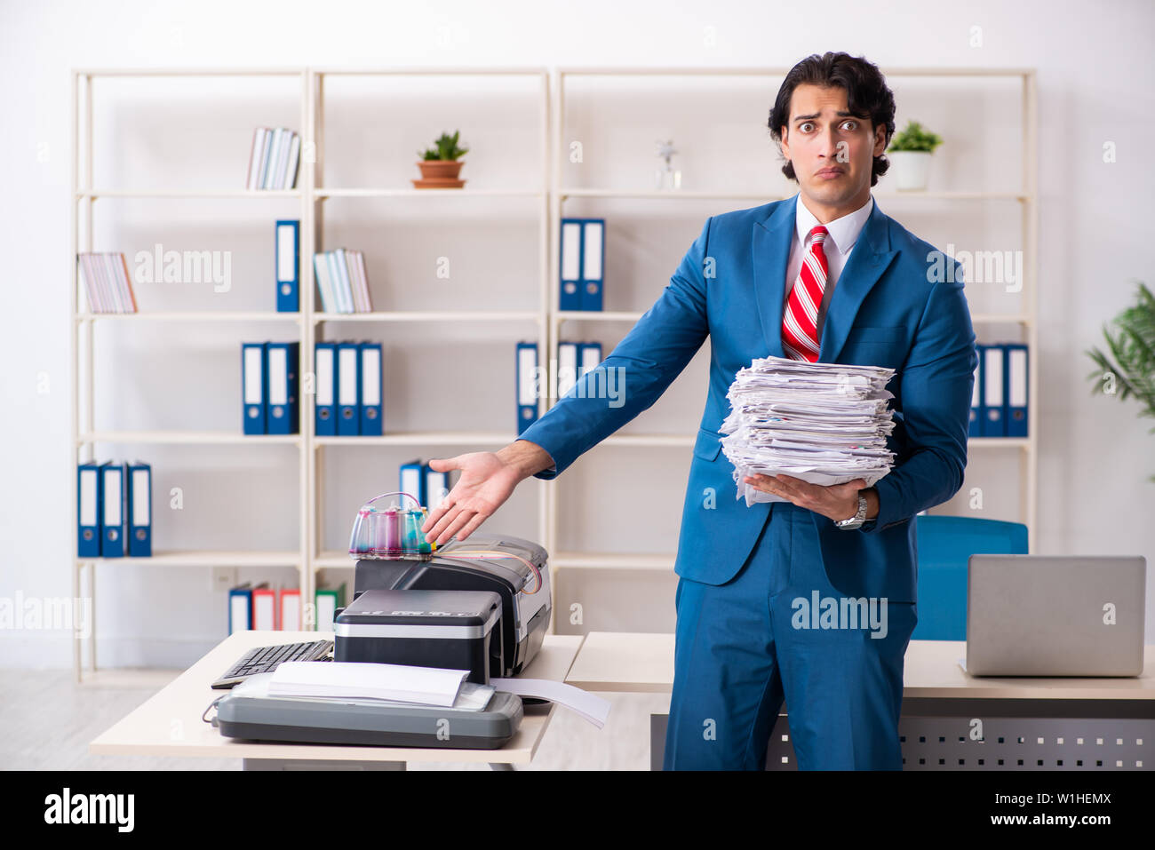 Young employee making copies at copying machine Stock Photo - Alamy