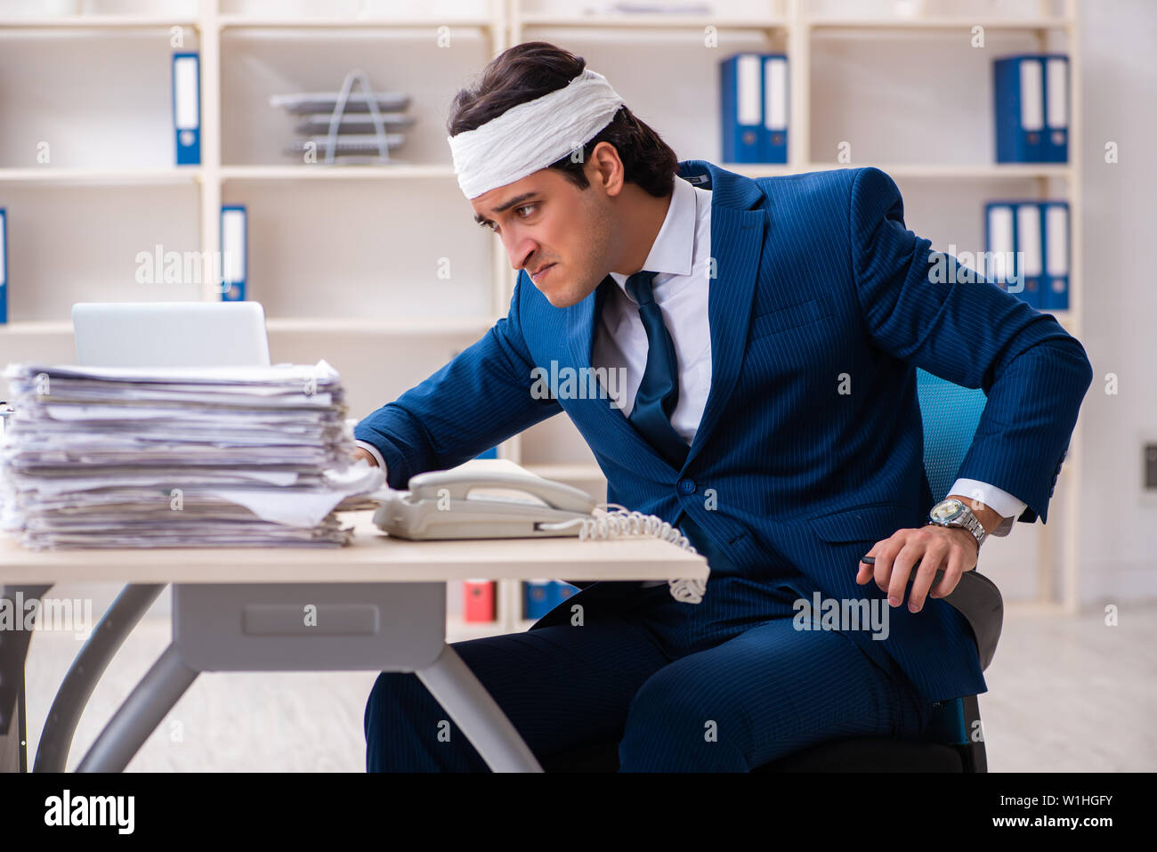 Head injured male employee working in the office Stock Photo - Alamy