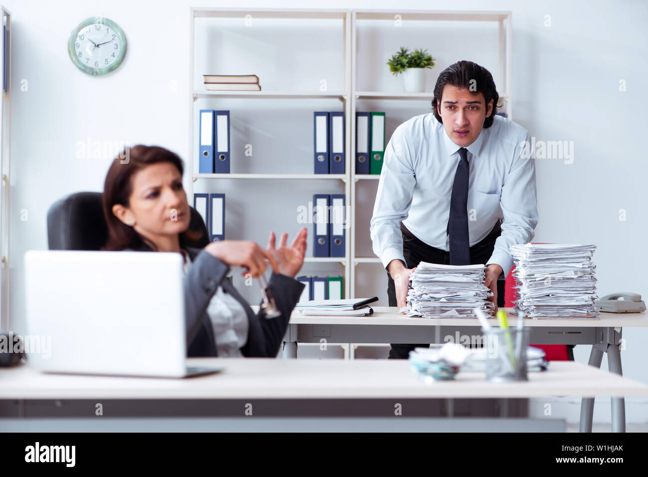 Old female boss and young male employee in the office Stock Photo - Alamy