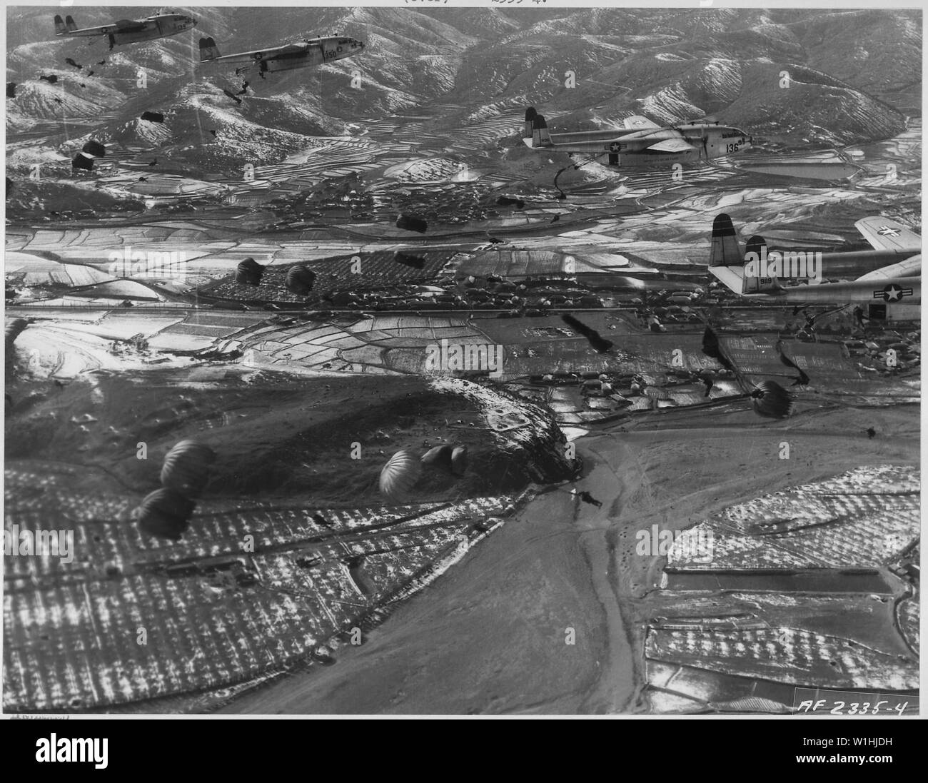 Parachutes billow out behind a formation of 314th Troop Carrier Group C ...