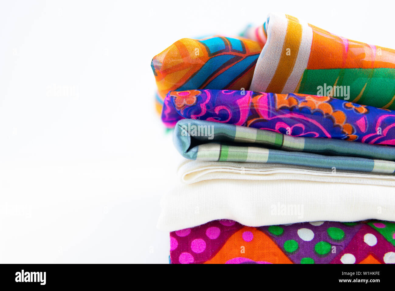 Stacked fabrics with vivid colors and patterns. Isolated on white ...