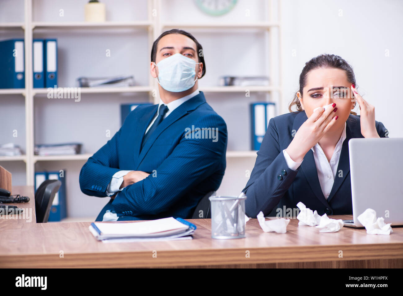 Two employees suffering at workplace Stock Photo - Alamy