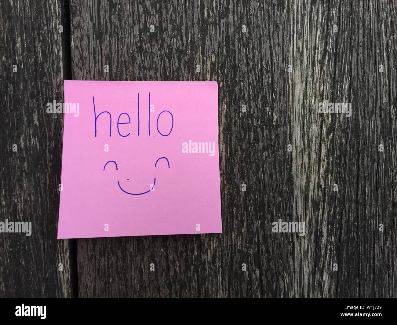 Hello text letter on wooden background. Top view pink reminder note ...