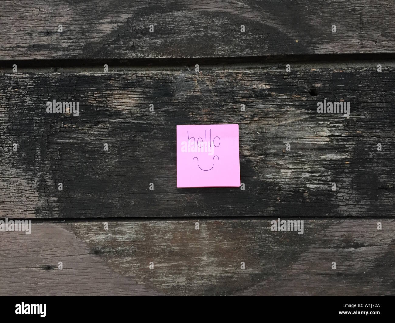 Hello text letter on wooden background. Top view pink reminder note ...
