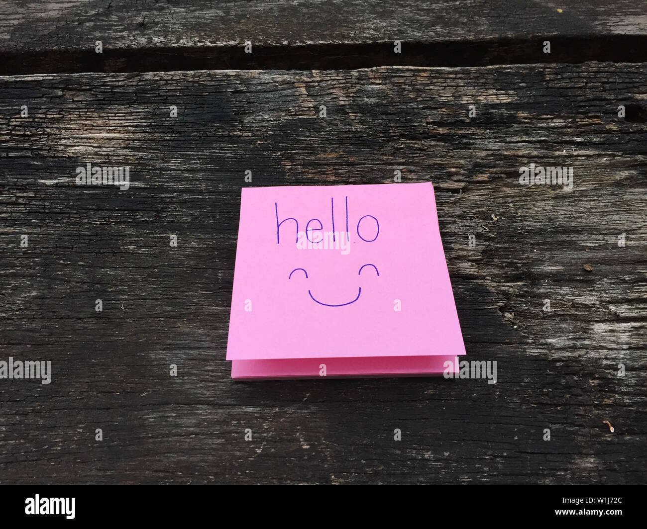 Hello text letter on wooden background. Top view pink reminder note ...