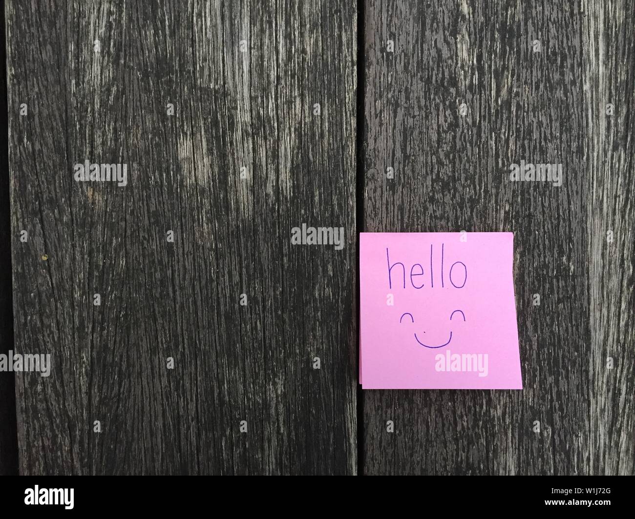 Hello text letter on wooden background. Top view pink reminder note ...