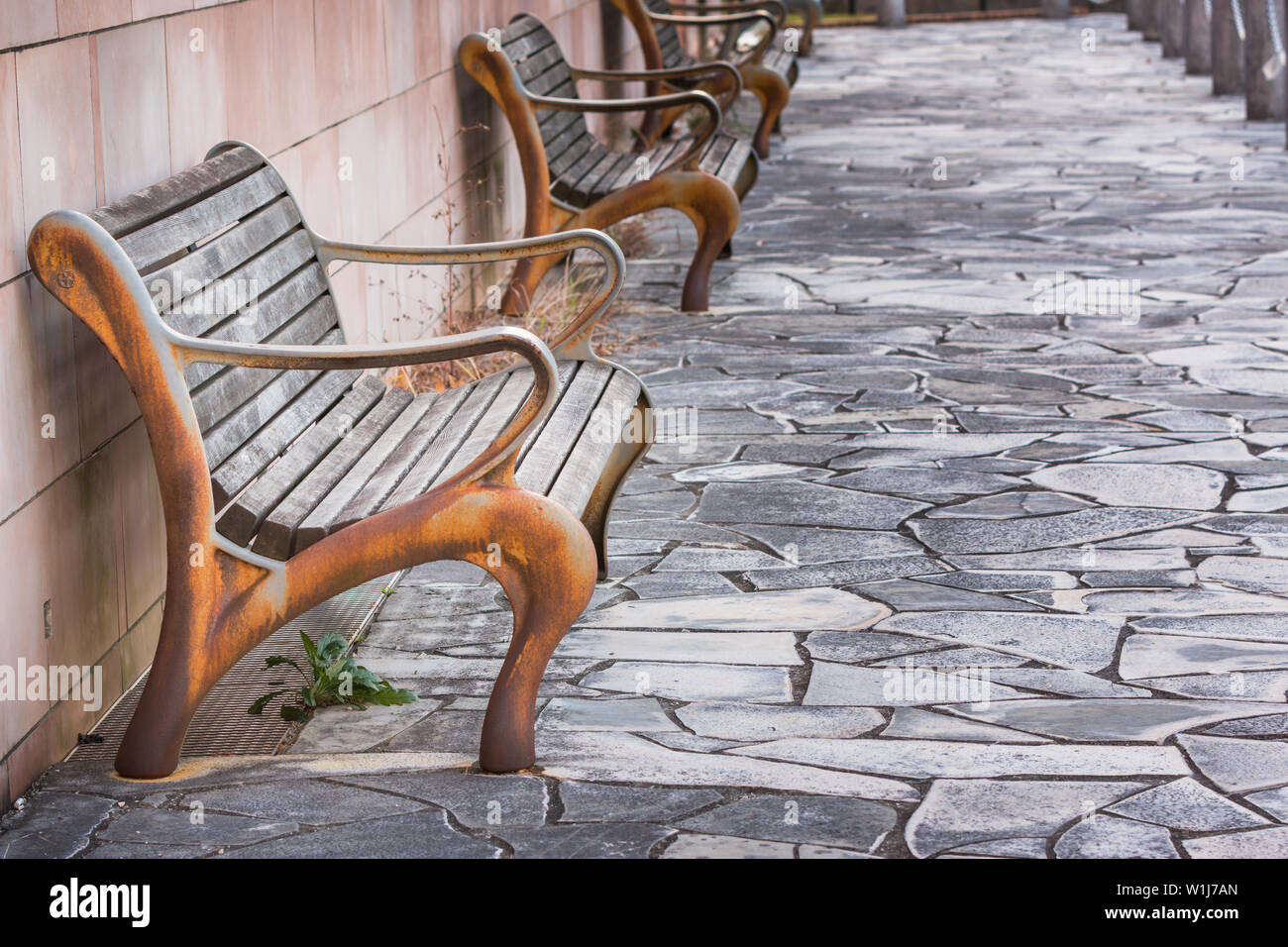 vintage old rusty bench beside red brick wall Stock Photo - Alamy