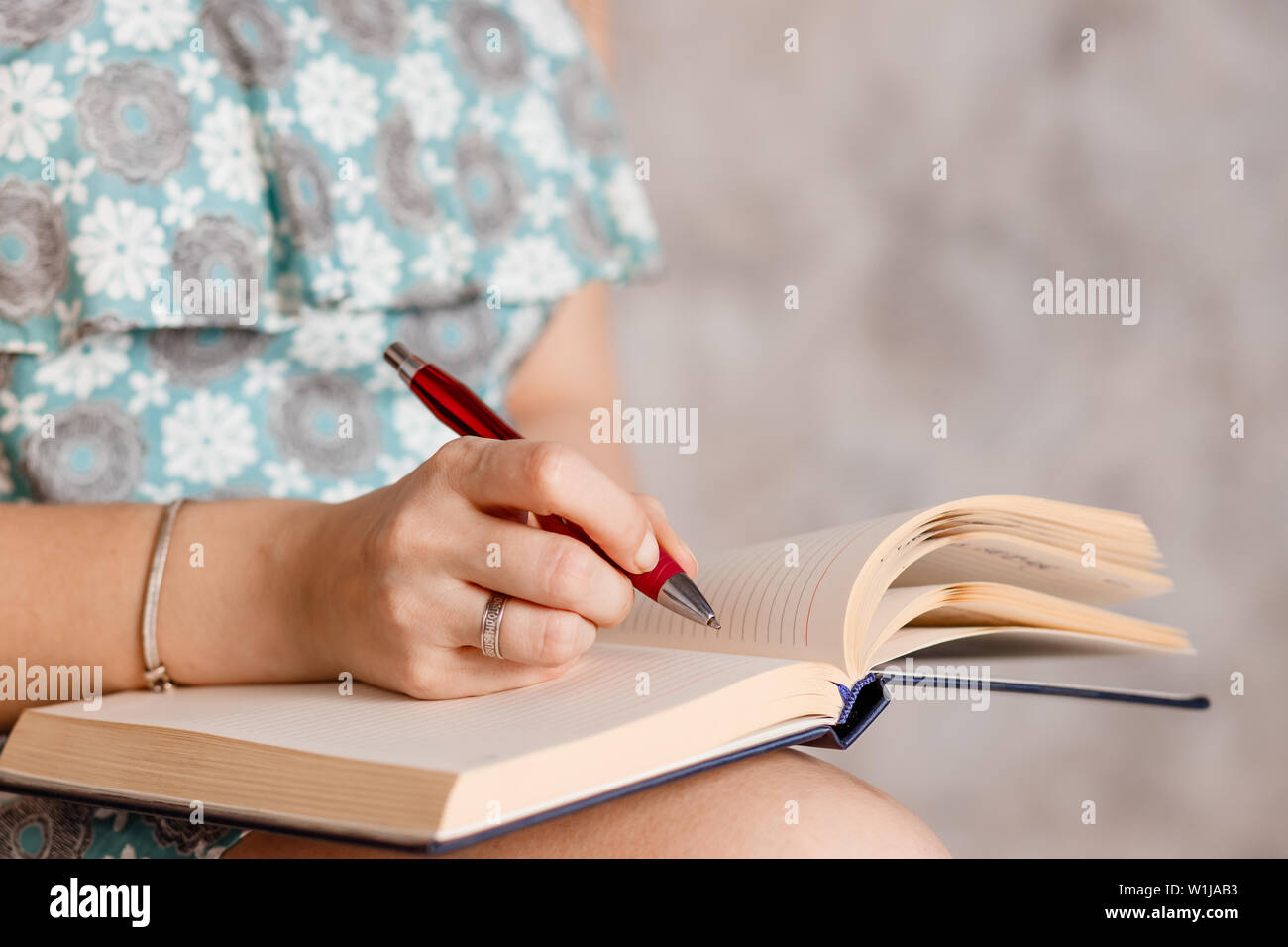 Front View of woman's hands writing useful information in notepad.Girl ...