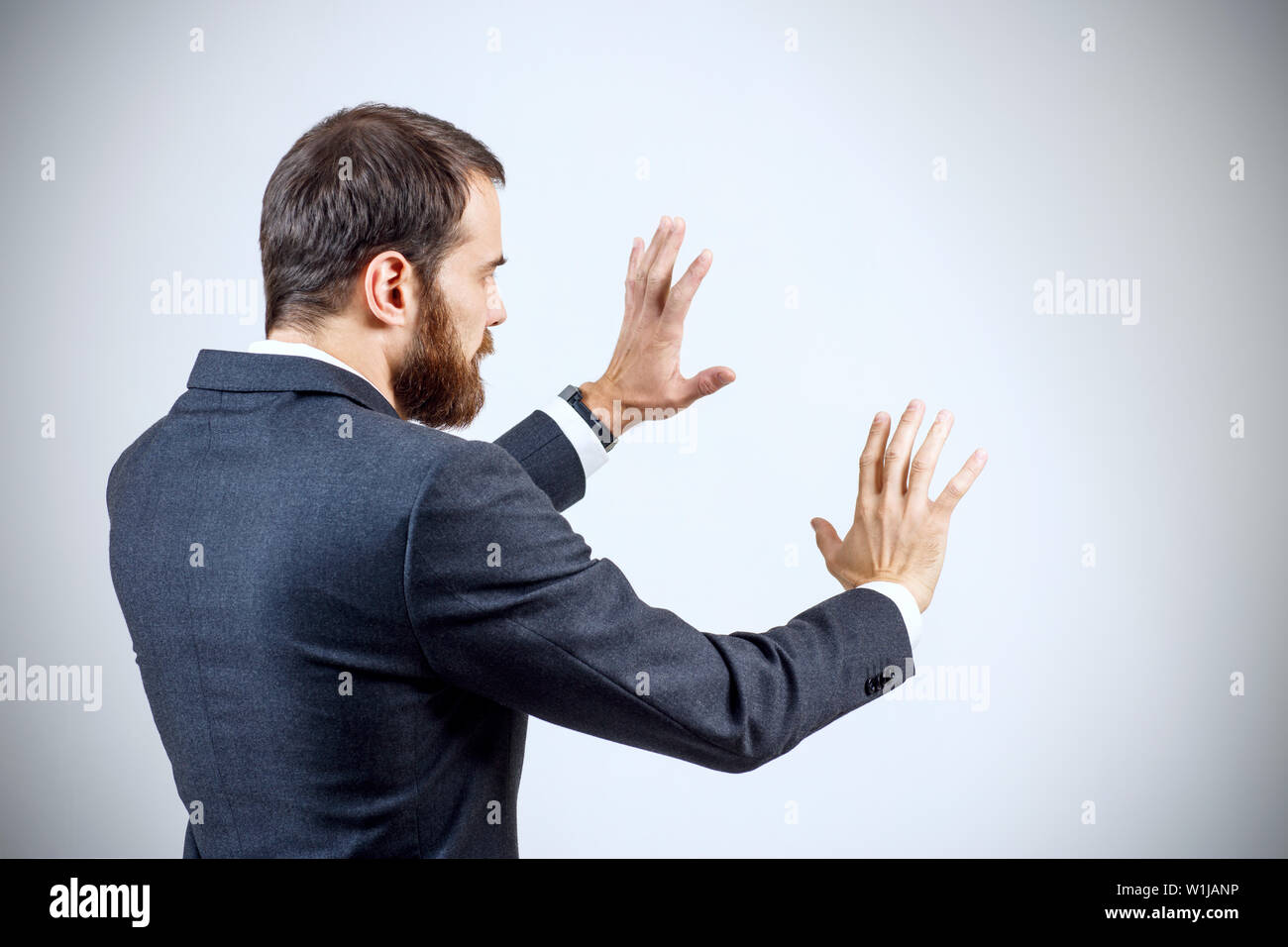 Businessman in suit shows outstretched hand withspread fingers. Over ...