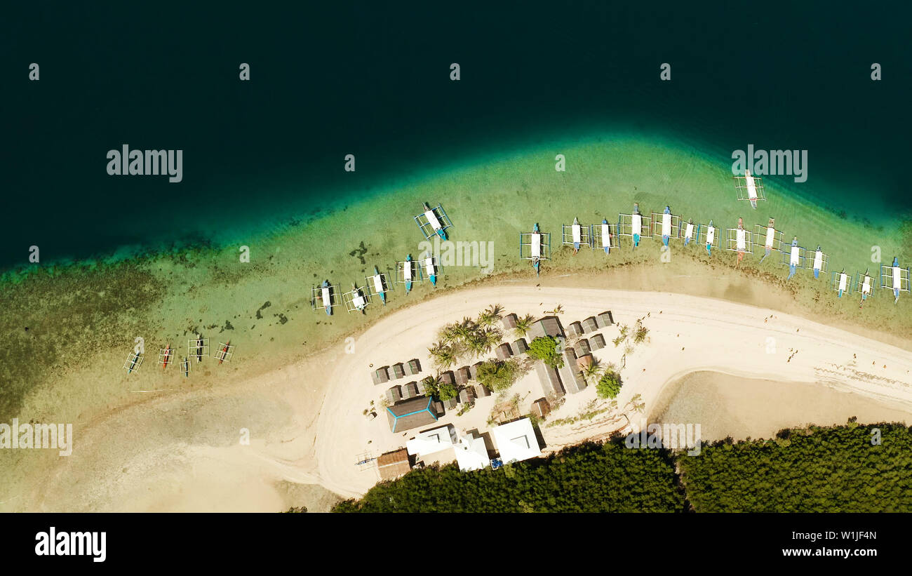 Tropical island and sandy beach with tourists surrounded by coral reef ...