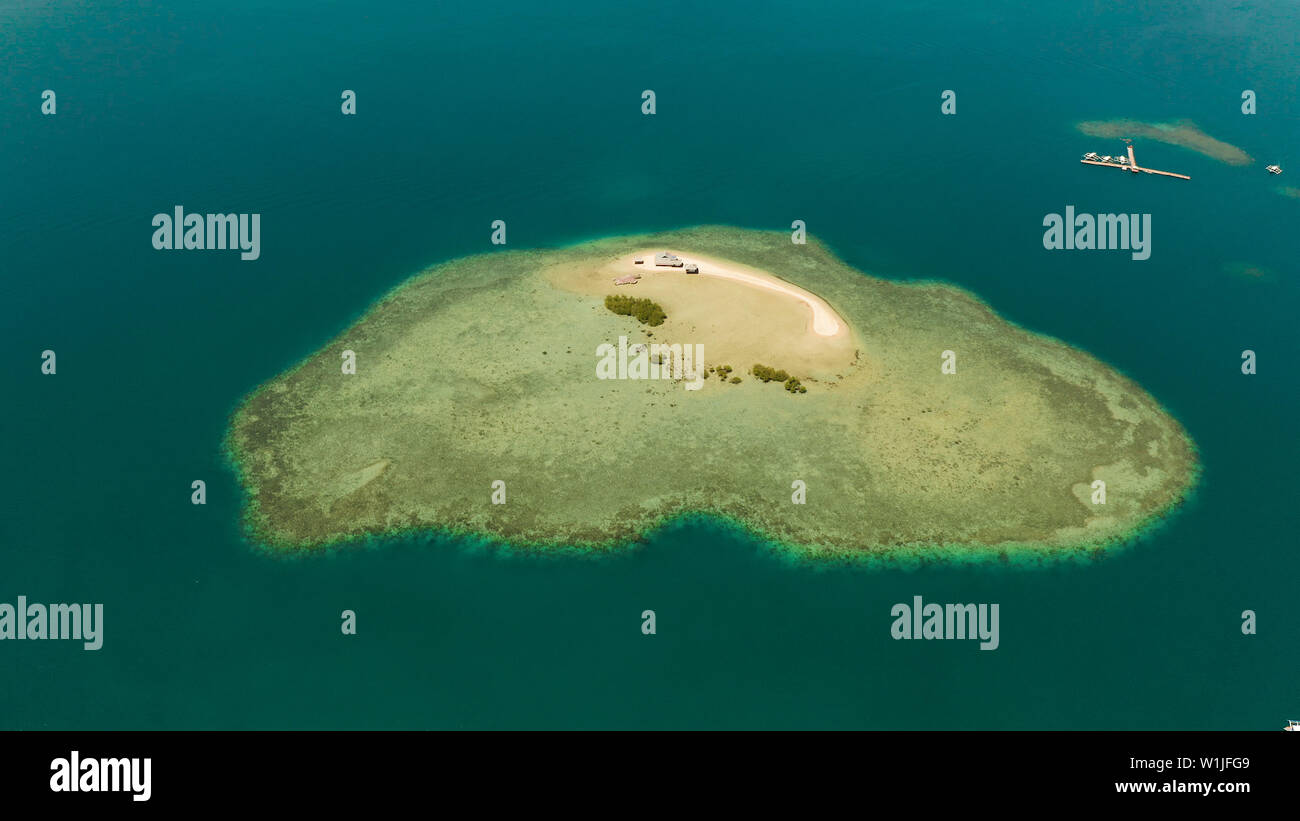 Sandy island with sand bar surrounded by coral reef and blue sea in ...