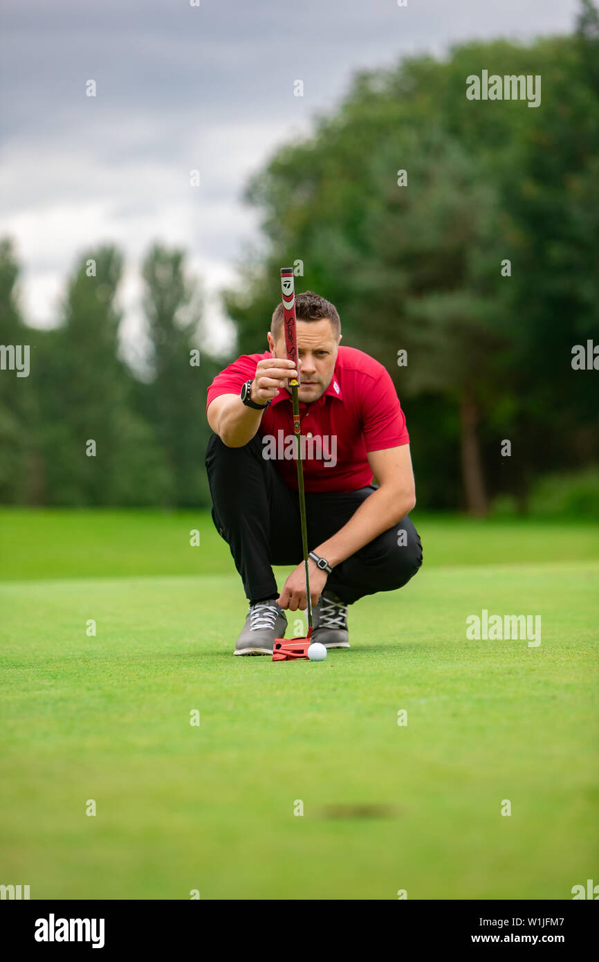 A professional golfer putting on the green Stock Photo - Alamy