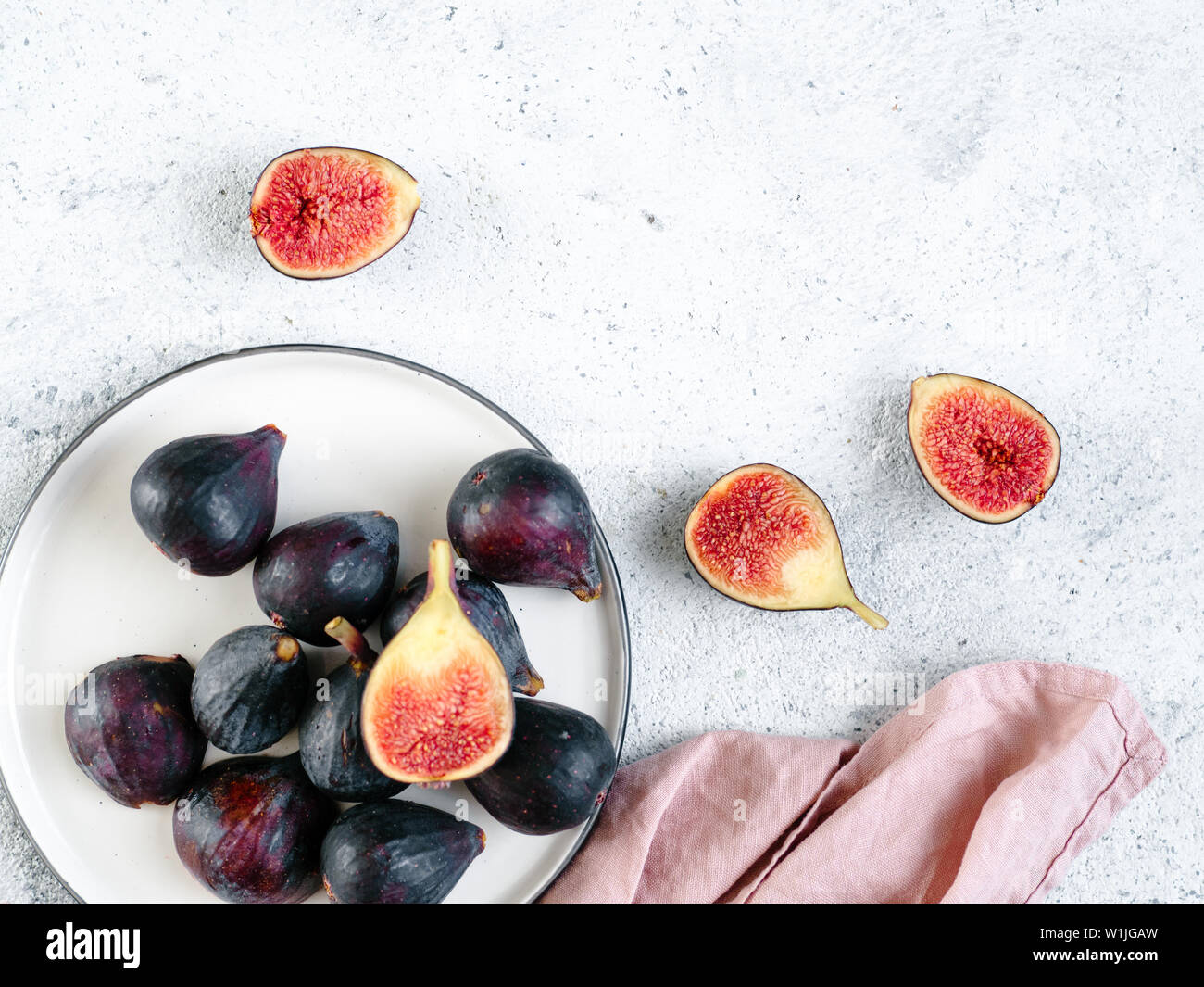 Half and whole figs on gray cement or stone background. Ripe violet ...