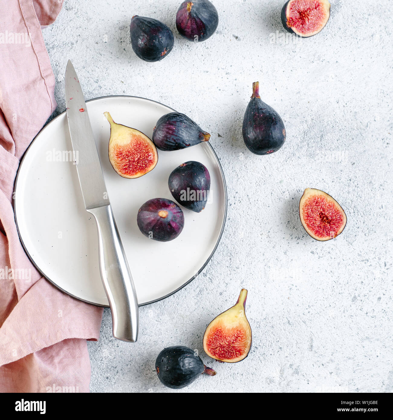 Half and whole figs on gray cement or stone background. Ripe violet ...