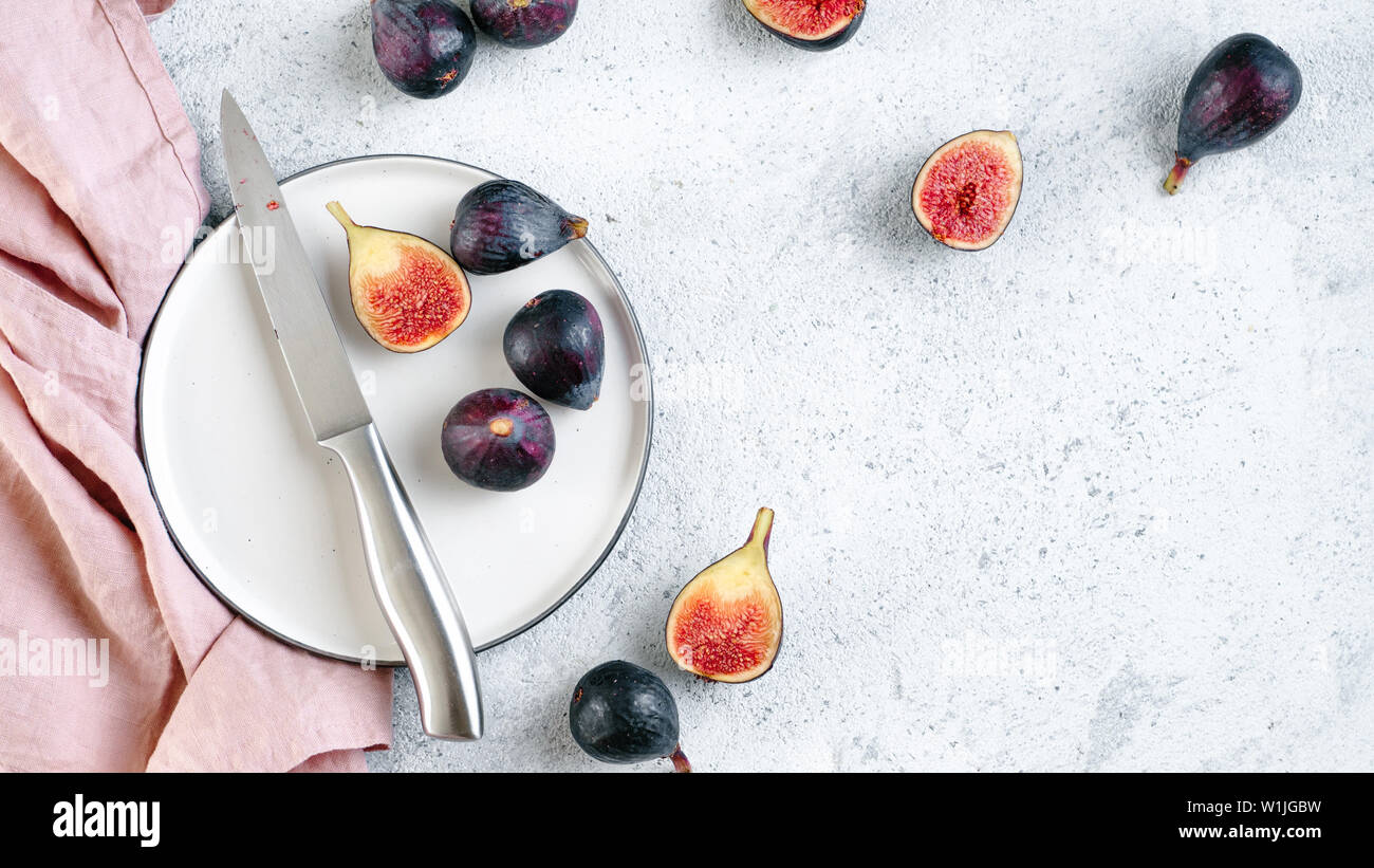 Half and whole figs on gray cement or stone background. Ripe violet ...