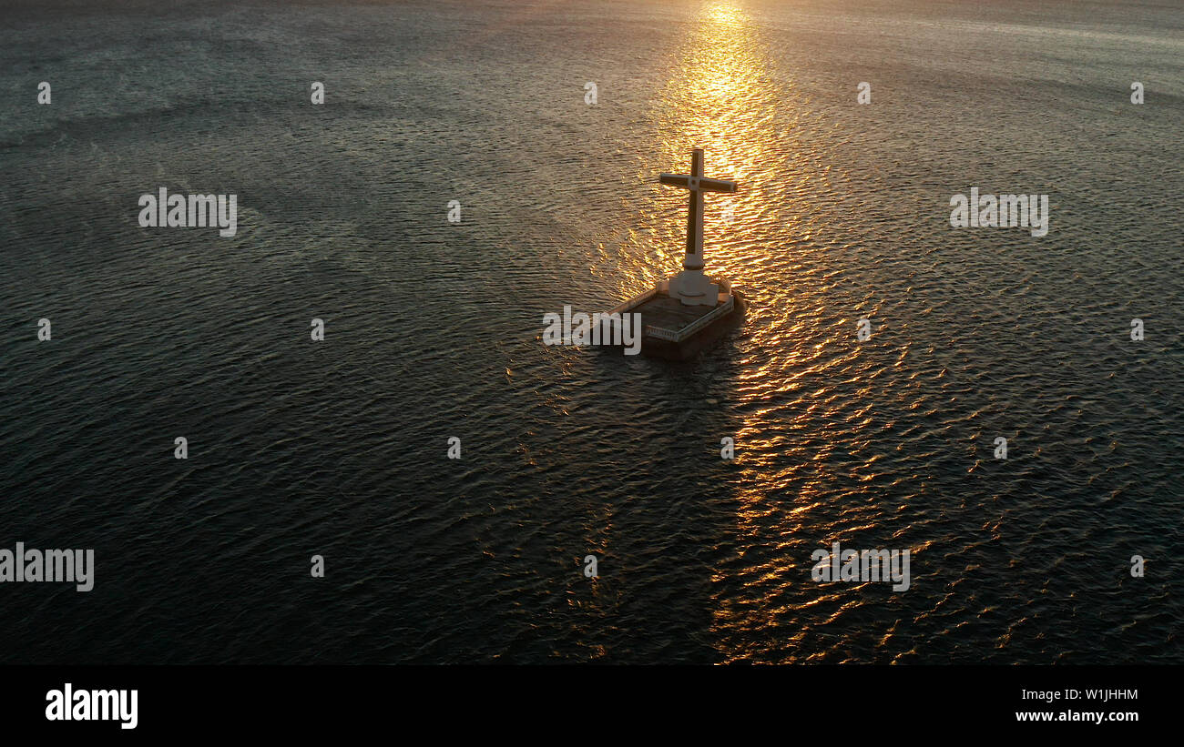 Catholic cross in sunken cemetery in the sea at sunset, aerial view ...