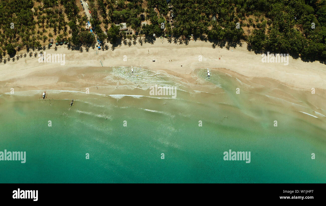 Tropical sandy beach with tourists in blue water, aerial view. Nagtabon ...