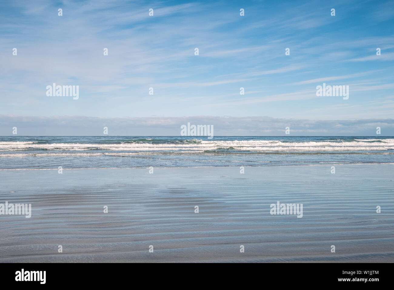 Clear sea with rippled beach and wave hitting Stock Photo - Alamy