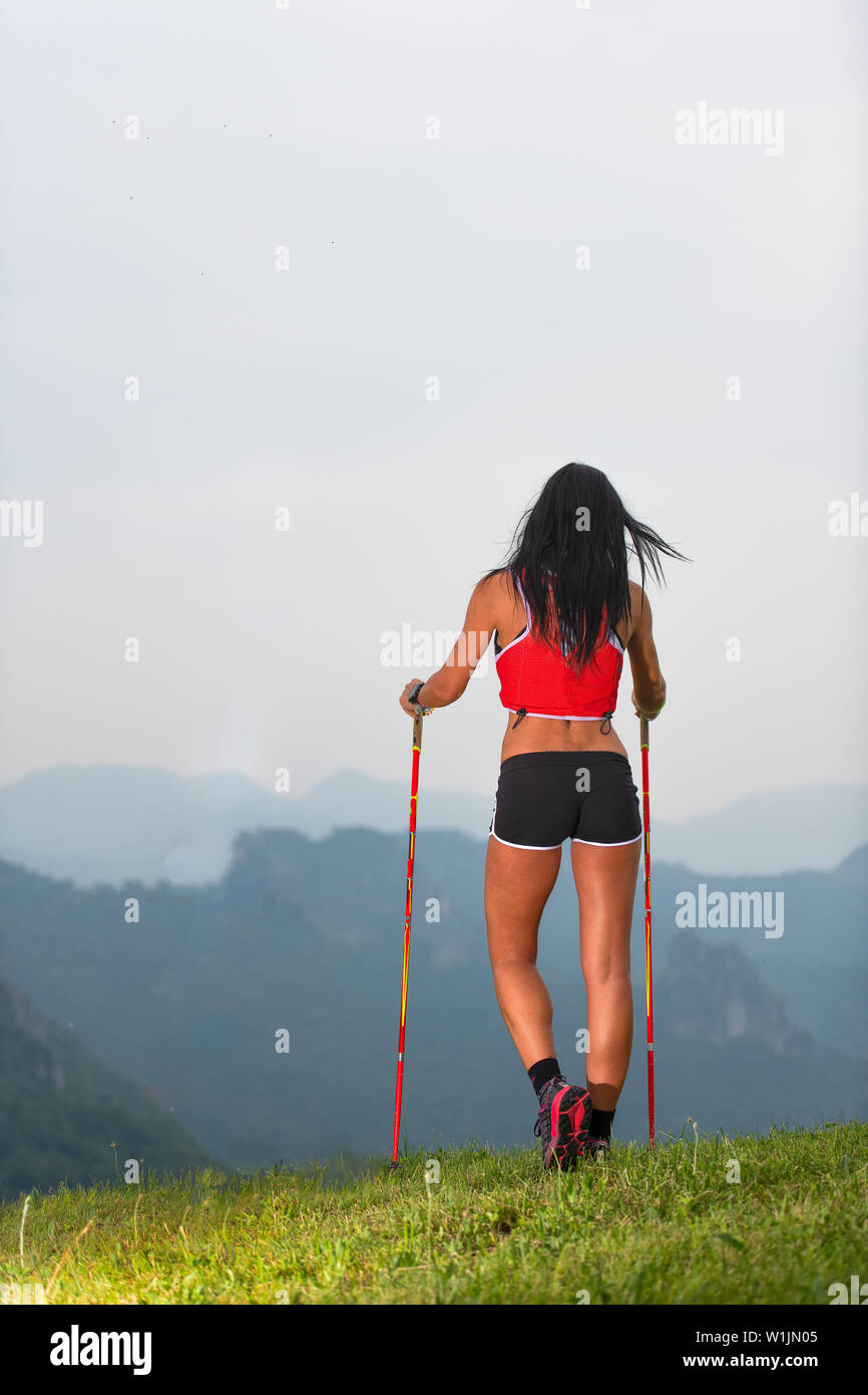 Sporty woman with nice body looks at the panorama in the mountains ...