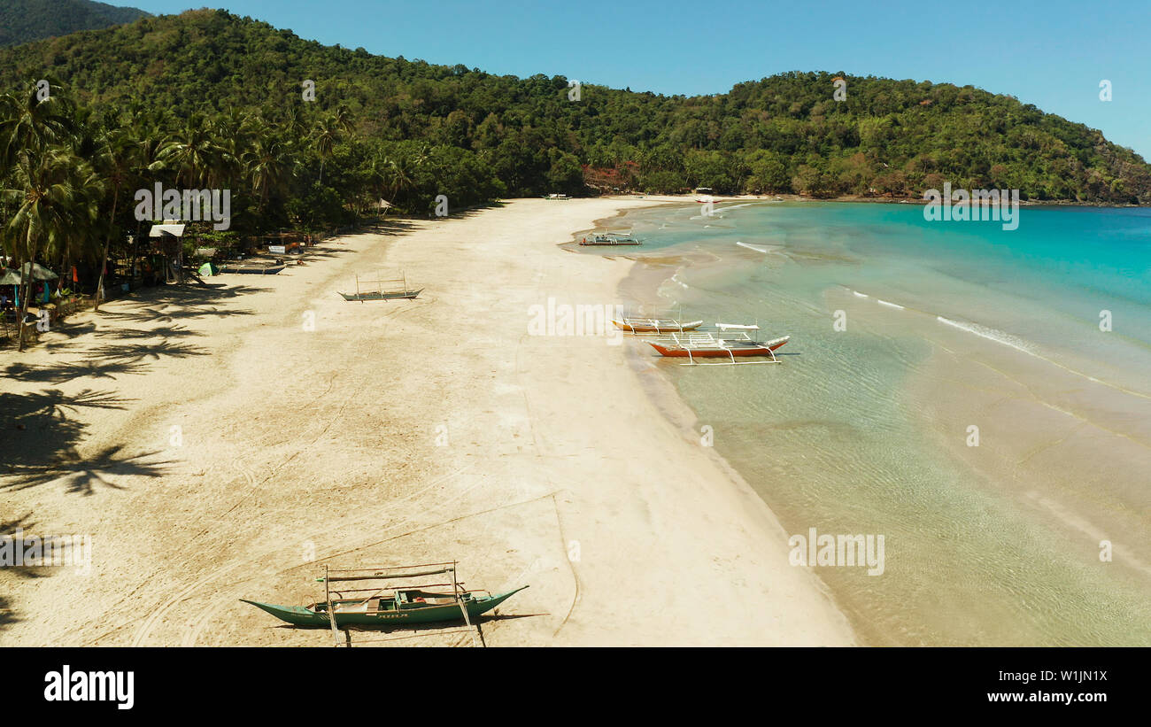 Tropical sandy beach with tourists in blue water, aerial view. Nagtabon ...