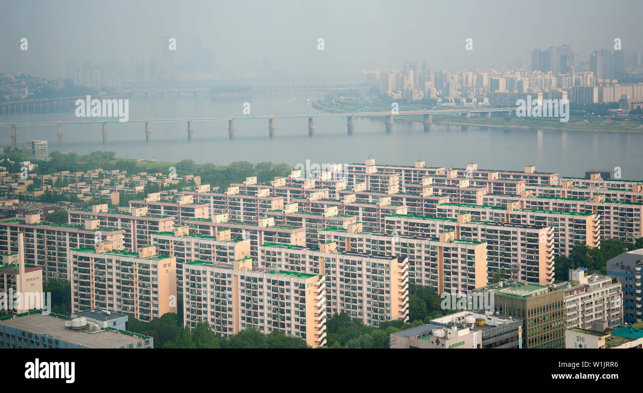 First rays of light cut through the hazy air to paint the high rise ...