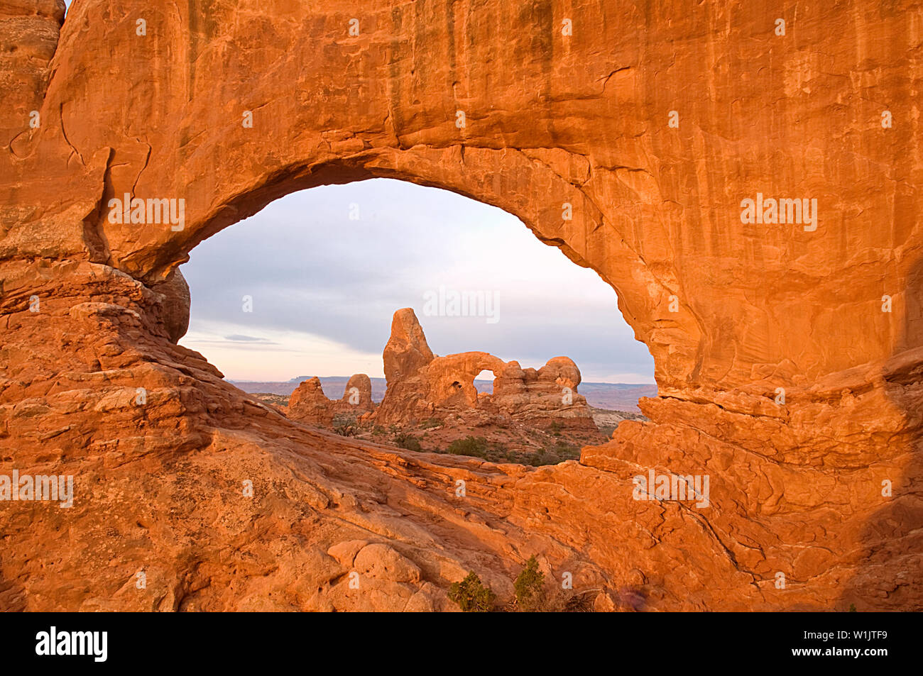 The morning sun paints the redrock of the North Window and Turret Arch ...