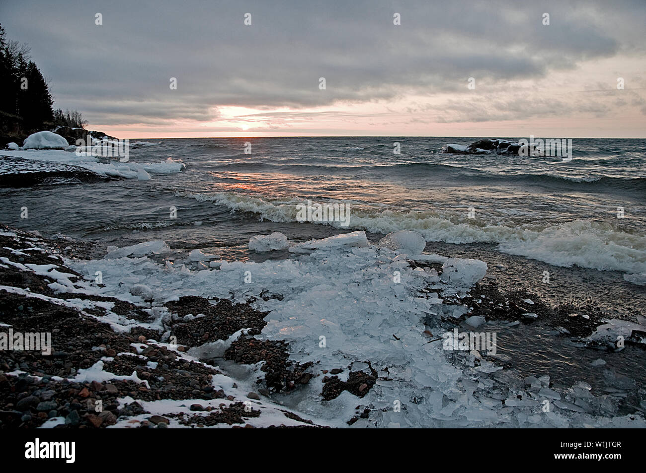 The sun comes up over the Ice and snow as the Poplar River makes its ...