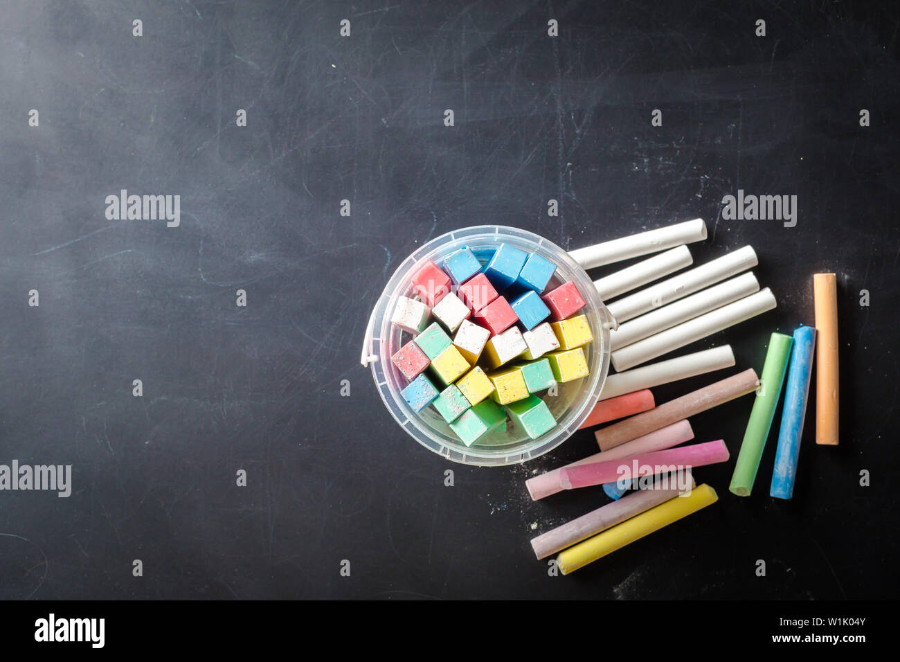 Dirty and used blackboard and pieces of colored chalk Stock Photo - Alamy