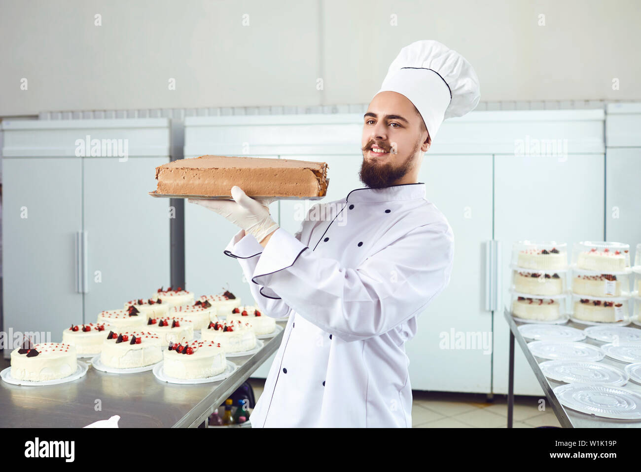 Confectioner smiling man holding cake smiling in a pastry shop Stock ...