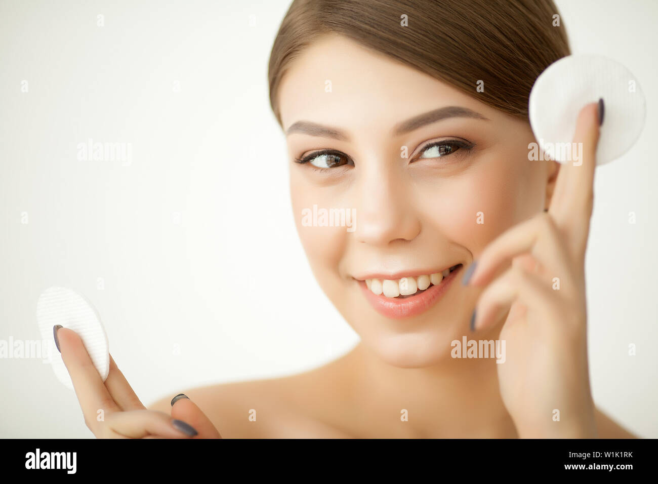 Beautiful young woman is cleaning her face Stock Photo - Alamy