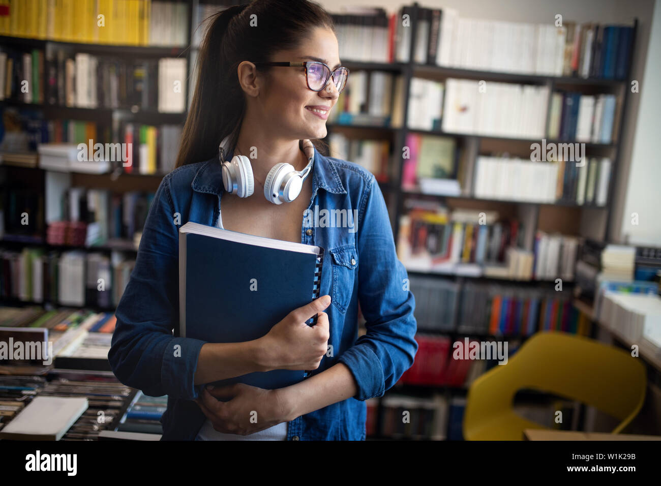 Beautiful happy student woman studying in library Stock Photo - Alamy