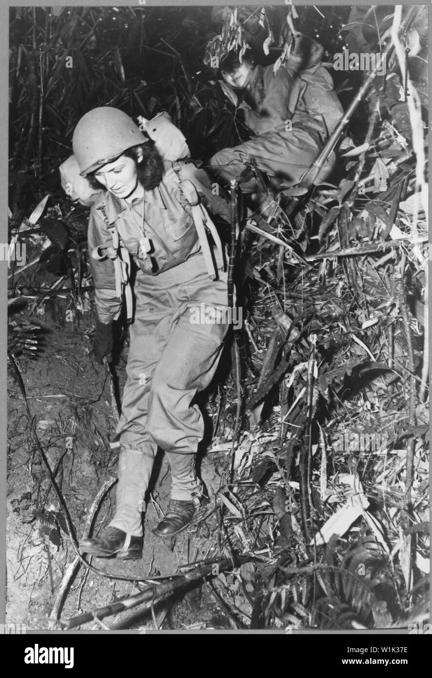 Two United States nurses carry heavy combat packs on a eight-mile hike ...
