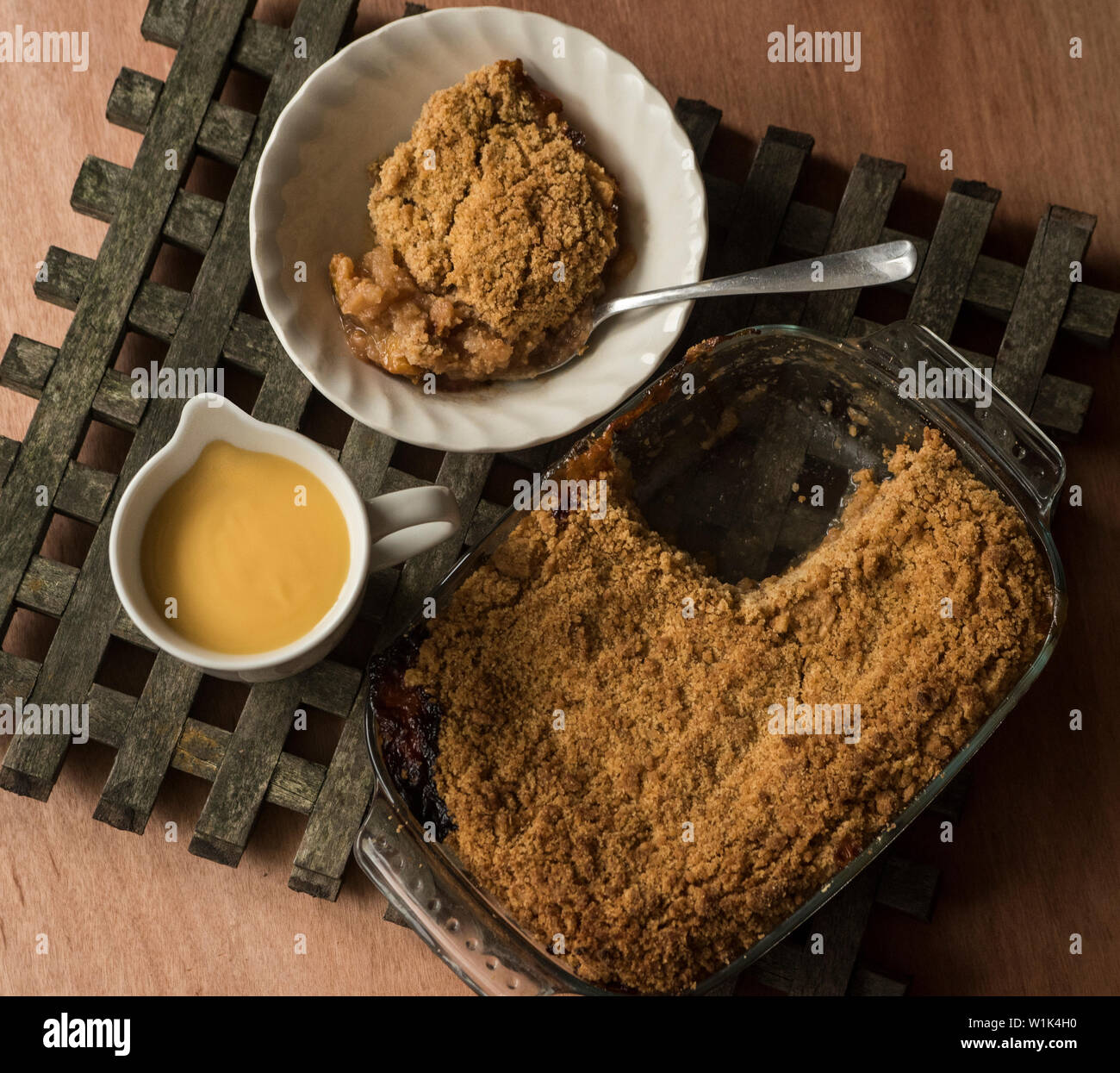 Classic English Autumn/ Fall dessert, warm Apple Crumble served with ...