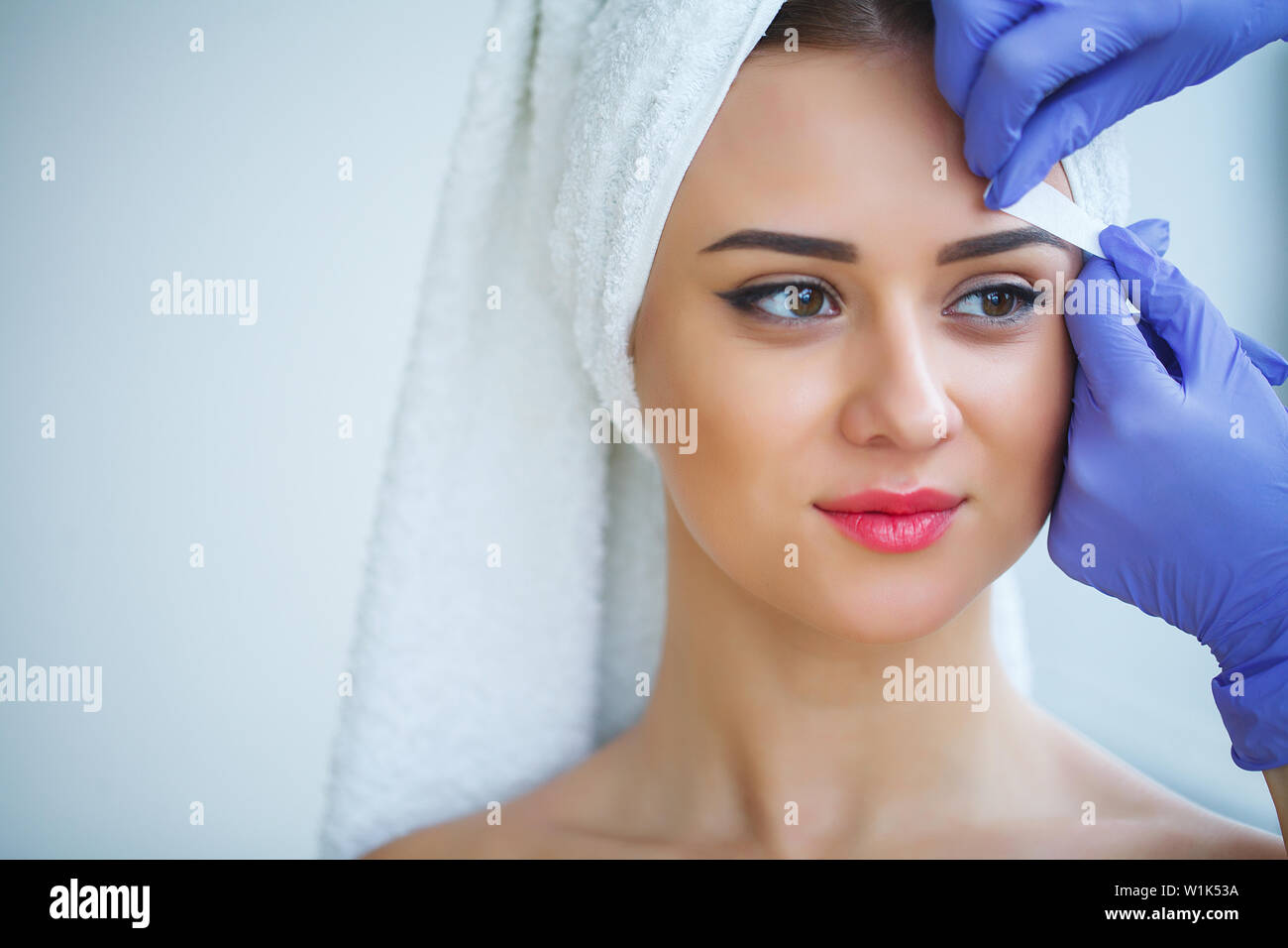 Skin care. Experienced cosmetician pulling out brows Stock Photo - Alamy