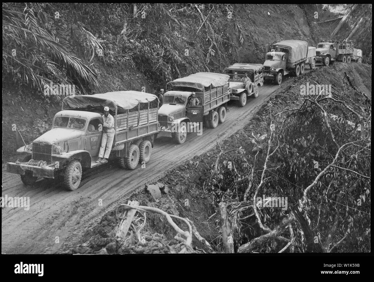 U.S.-built Army trucks wind along the side of the mountain over the ...