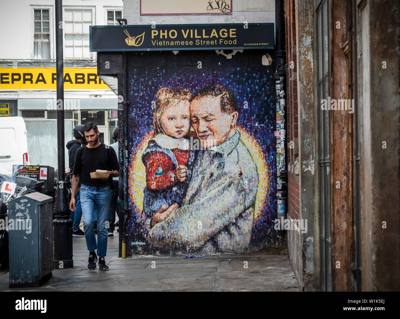 Man walking along street near Brick Lane in London Stock Photo - Alamy