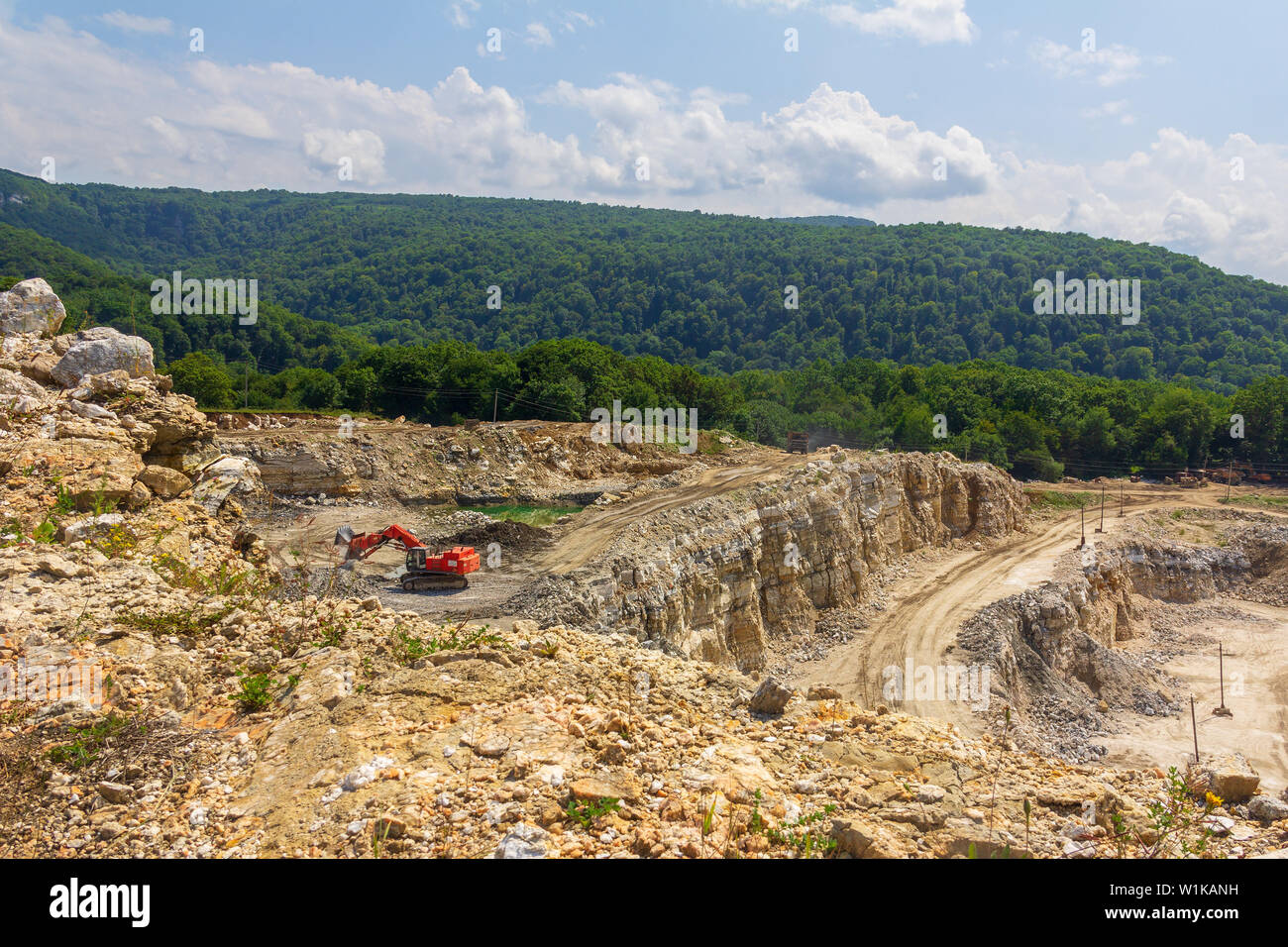 industrial landscape with an excavator in a quarry for the extraction ...