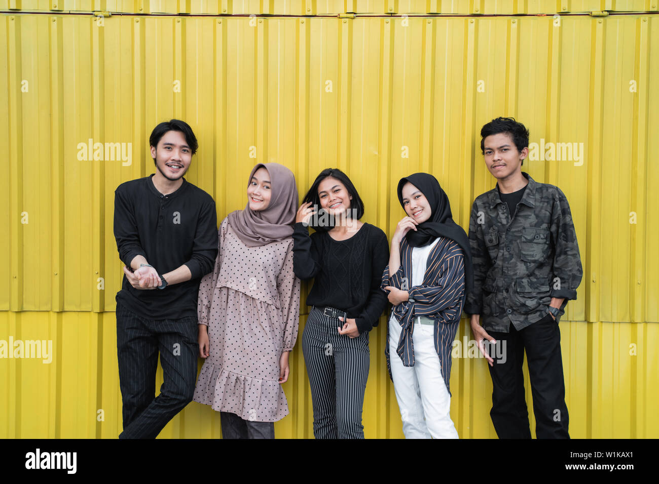 friends having fun outdoors standing lean back the wall Stock Photo - Alamy