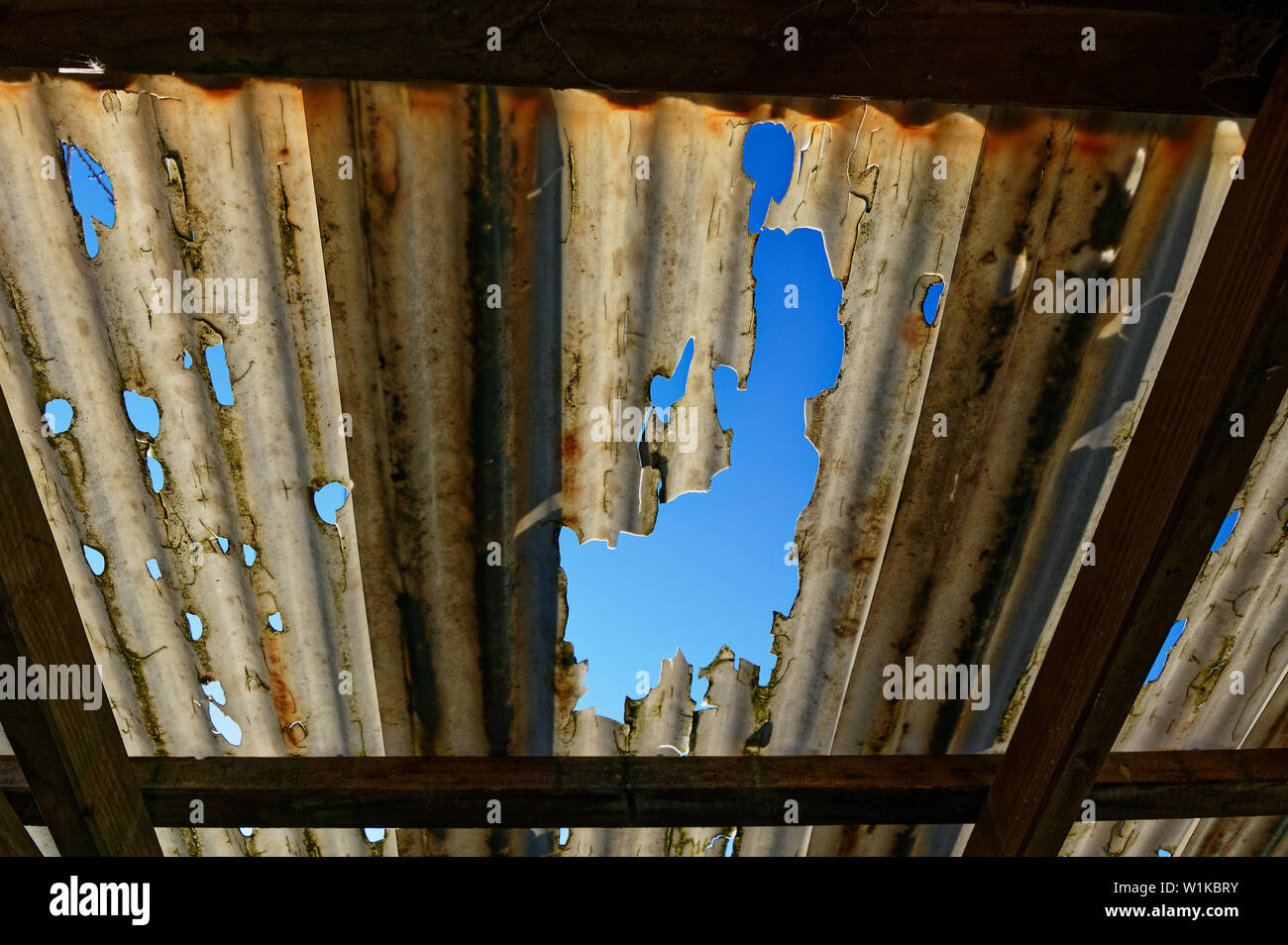 A roof with storm damage, the sky shows through it Stock Photo - Alamy