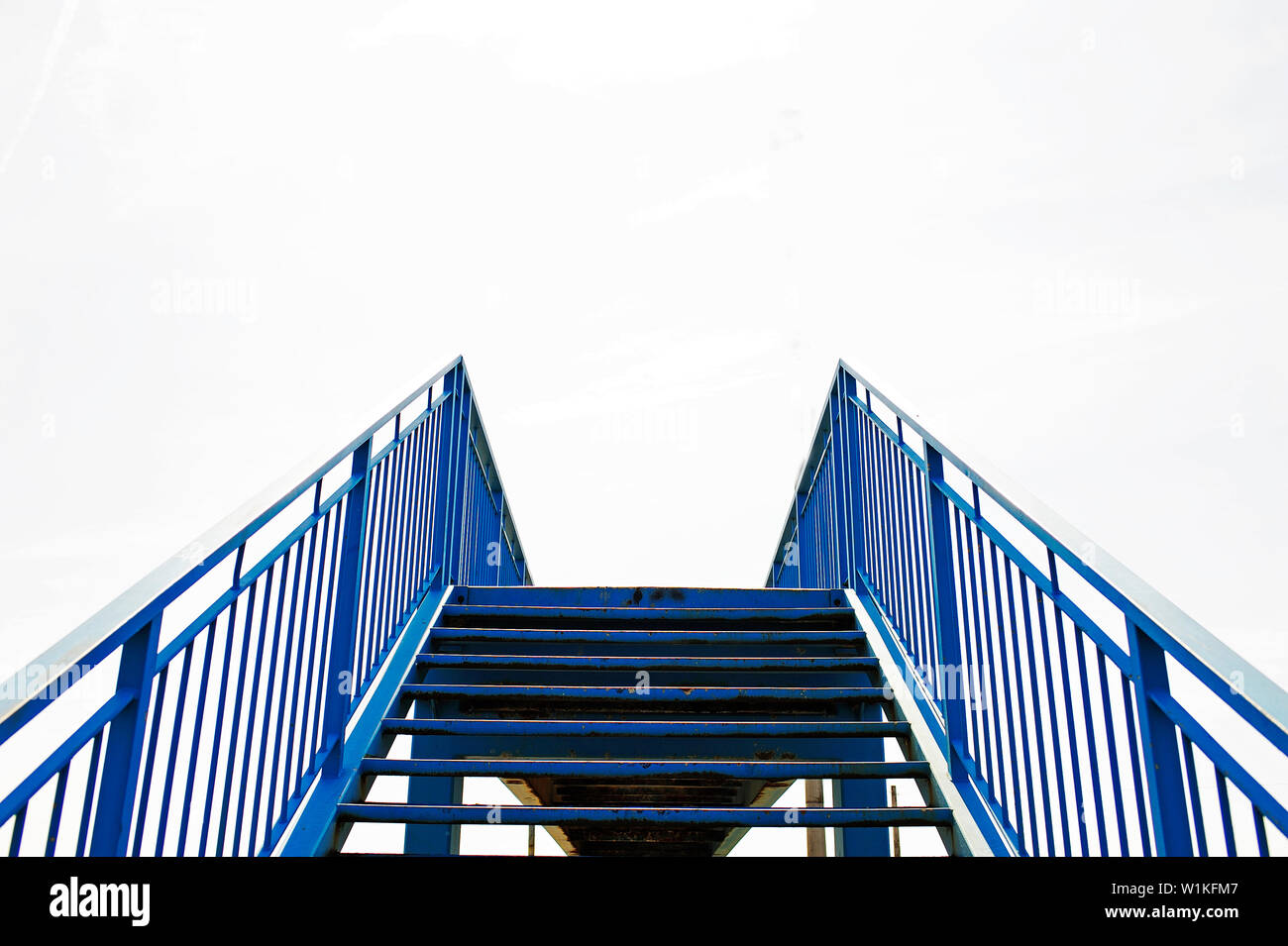 Blue metal footbridge against white sky Stock Photo - Alamy