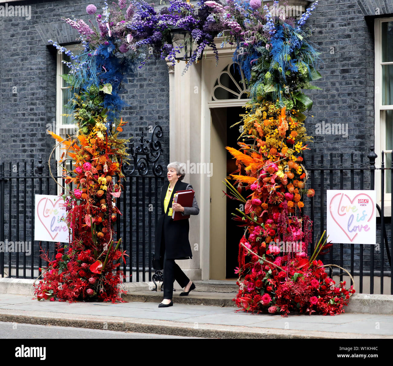 Theresa May leaves Downing Street through a gay pride flower arch Stock ...