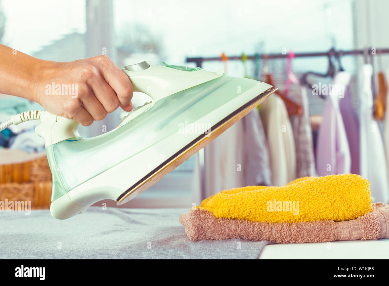 Closeup of woman ironing clothes on ironing board Stock Photo - Alamy