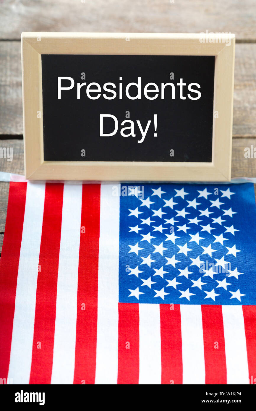 the text happy presidents day written in a chalkboard and a flag of the ...