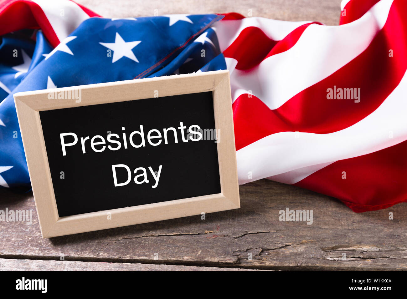 the text happy presidents day written in a chalkboard and a flag of the ...